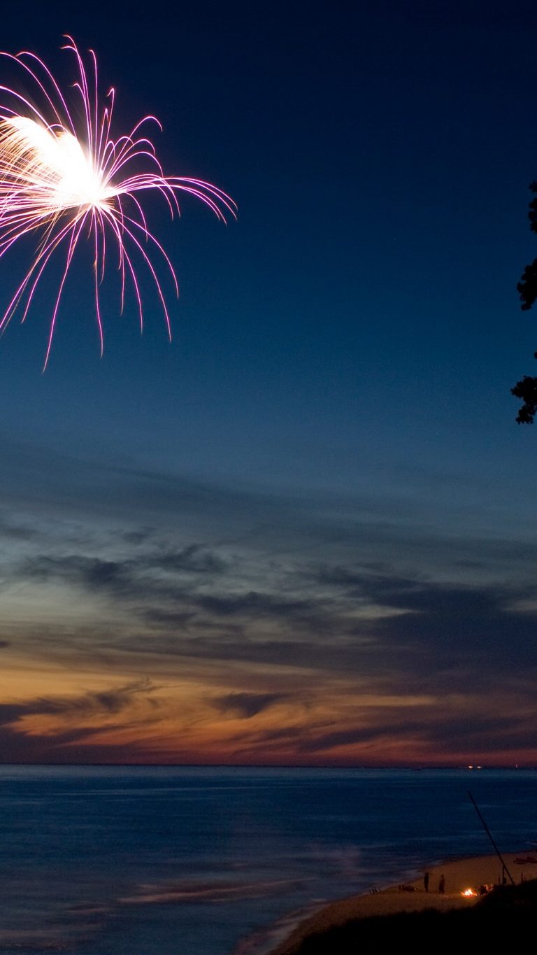 Fireworks on a beach at sunset | Windows Spotlight Images